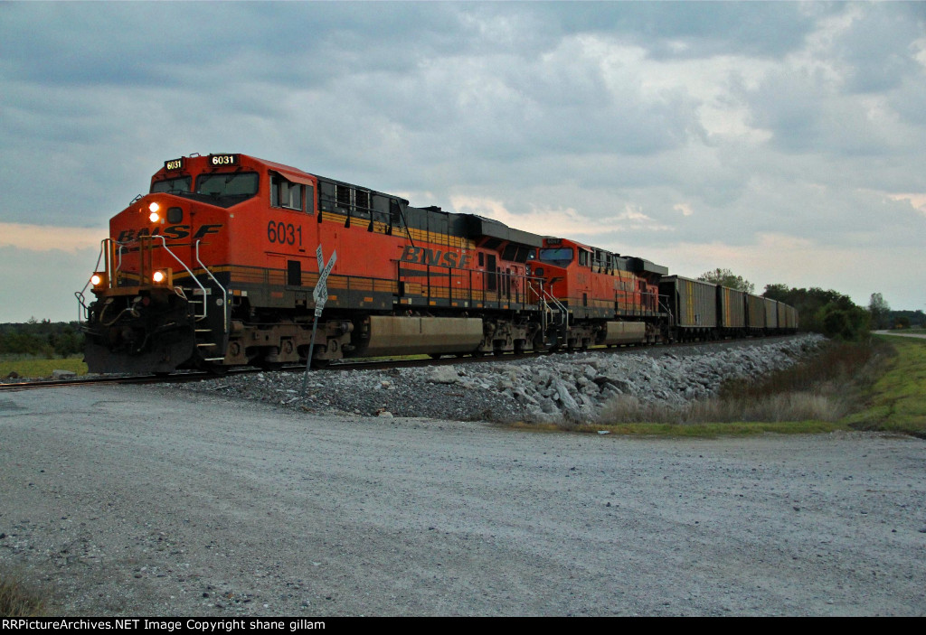 BNSF 6031 leads a empty coal at dark.